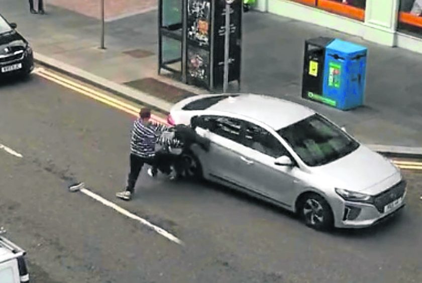 Moment man thrown into side of moving car during street fight captured ...