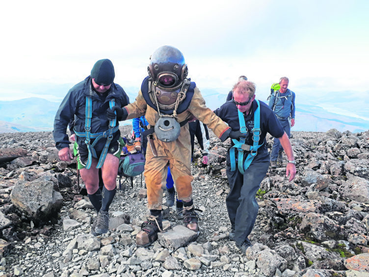 Climbers scale Ben Nevis wearing historic diving gear weighing 176 ...