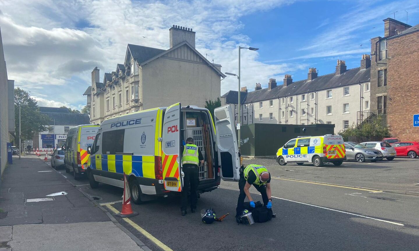 Riot police and forensics officers search block of flats in Perth