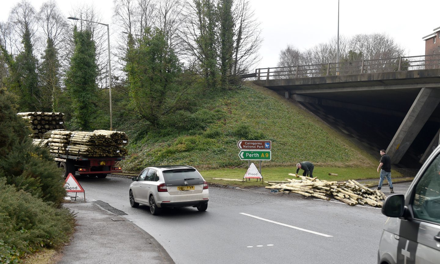 Lorry sheds its load of logs at Raigmore Interchange in Inverness