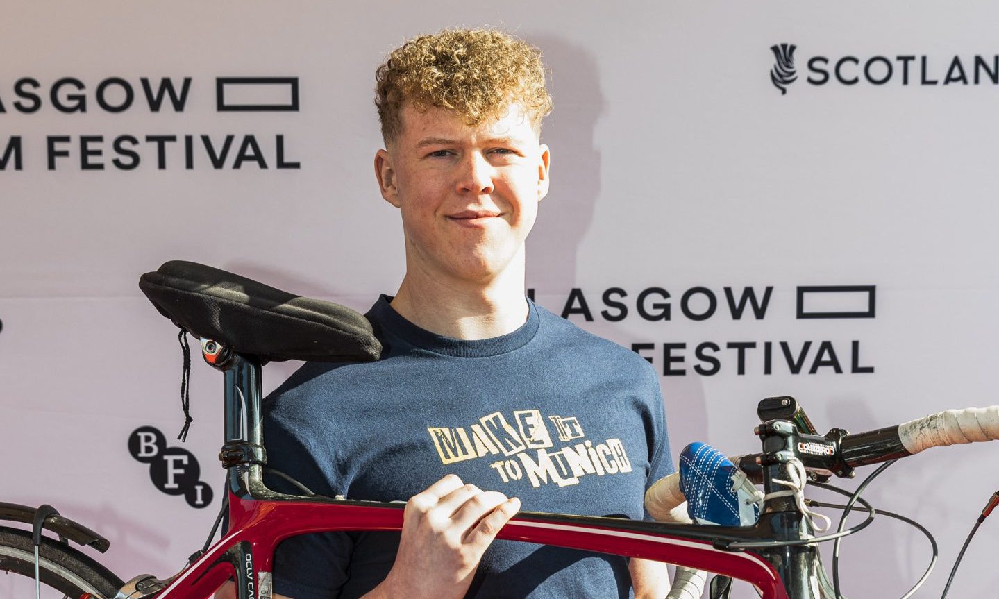 Make It To Munich: Ethan Walker cycles onto red carpet at premiere